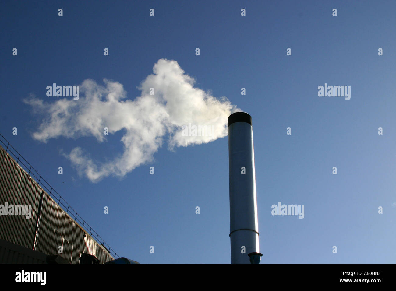 Steam emitting from a chimney top against a clear blue sky Stock Photo ...