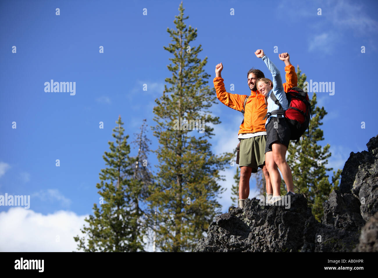Backpacking couple celebrate at the top of a mountain Stock Photo - Alamy
