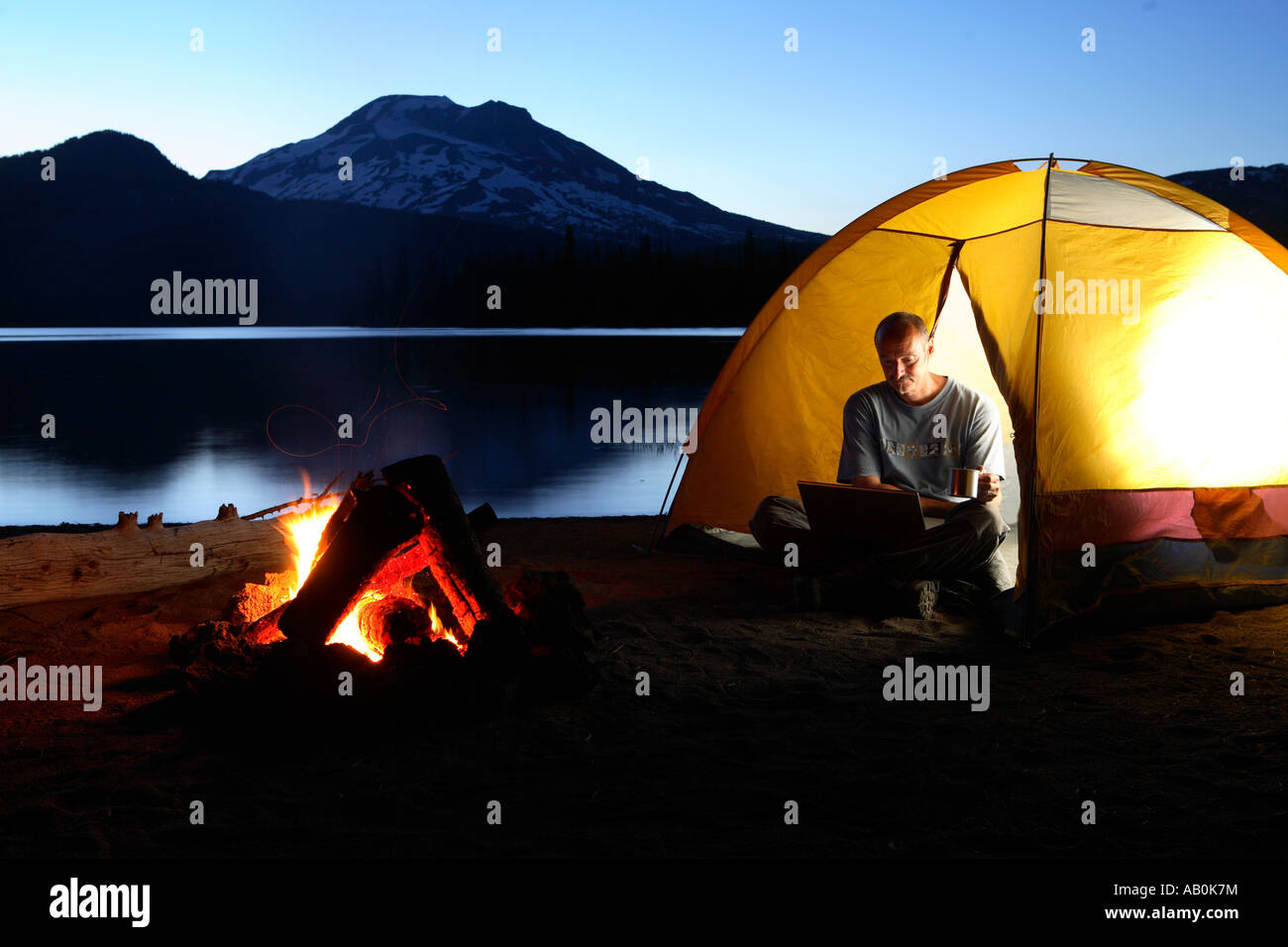 Man using laptop computer while camping Stock Photo - Alamy