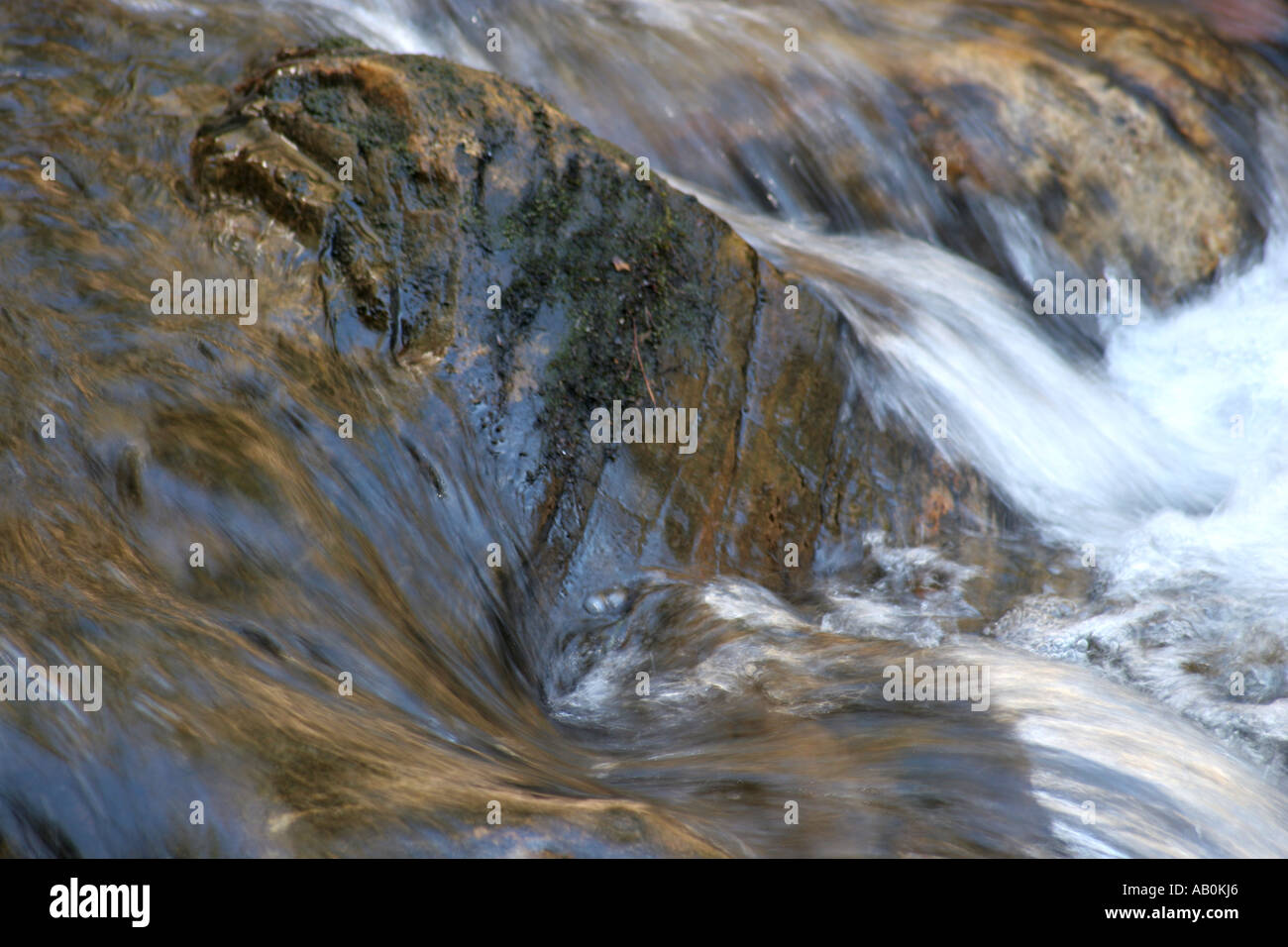 Stream with rocks and flowing water with dynamic reflections formed by ...