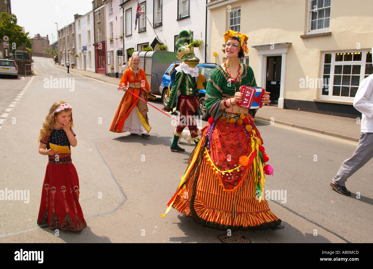 Performers from Giffords Circus one in green frog costume on street as ...