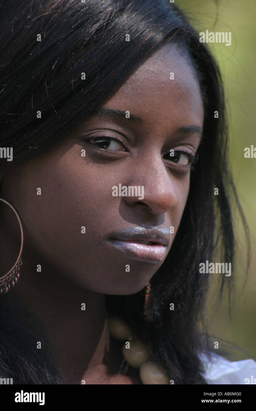 African American woman early 20s with wooden neckless and white blouse ...