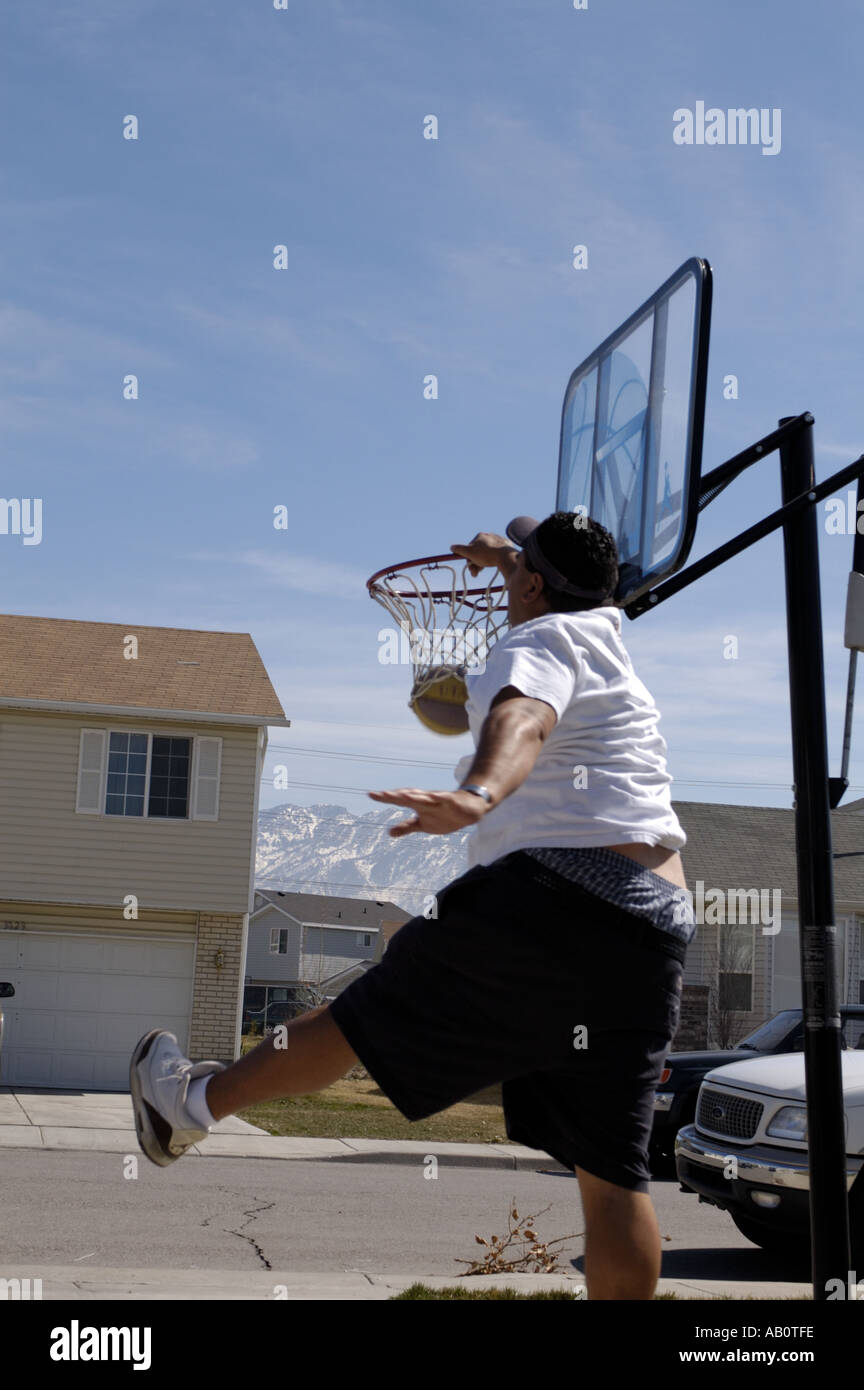 Man slamming basketball through hoop Stock Photo - Alamy