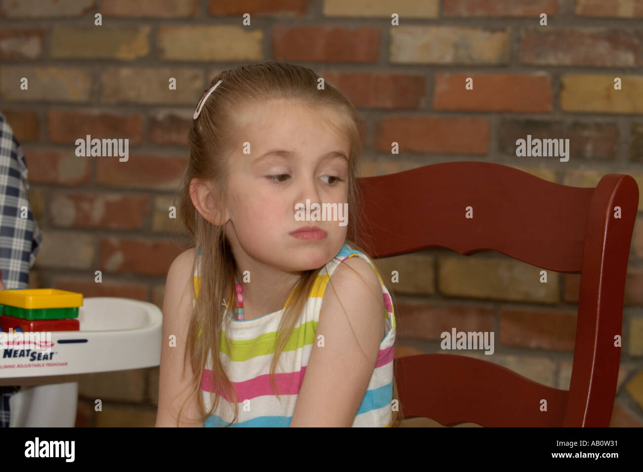 Little girl sitting with smug expression on her face Stock Photo - Alamy