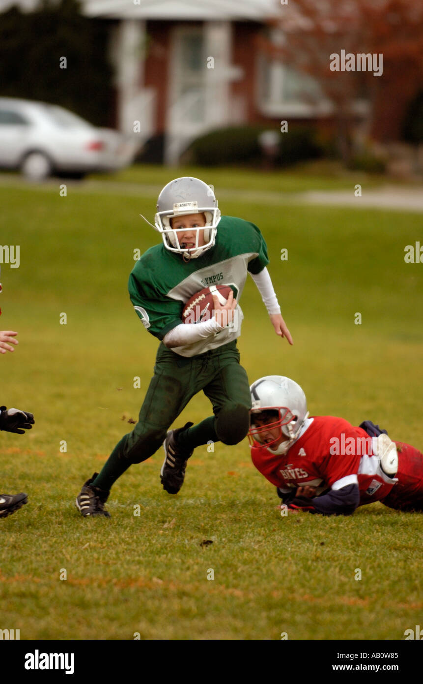 Football player carrying ball escaping a tackle Stock Photo - Alamy