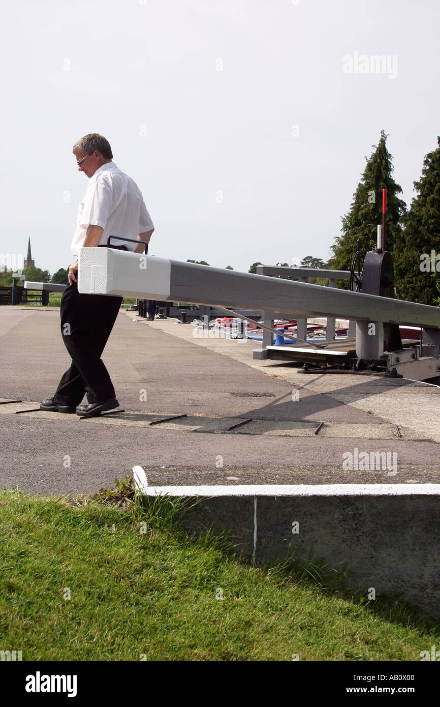 Lockkeeper pushing lock door open River Thames Lock gates near Lechlade ...