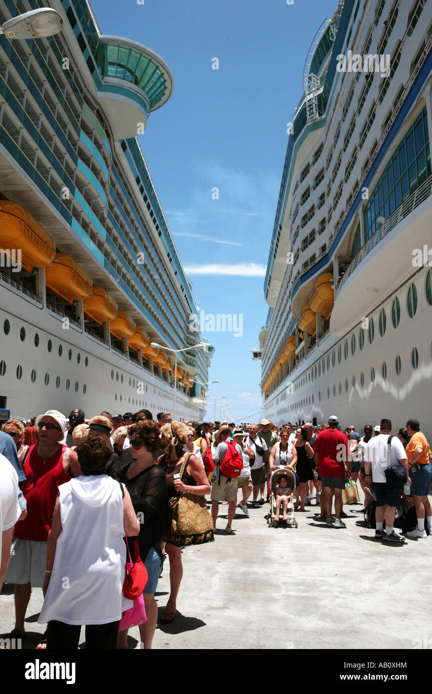 Two cruise ships docked alongside each other with people disembarking ...