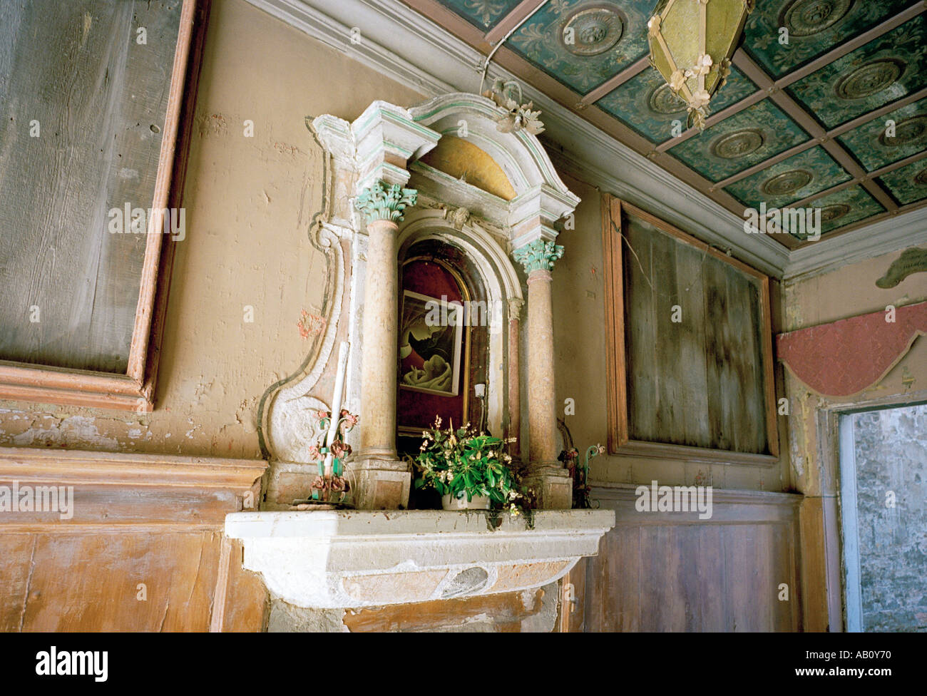 An old devotional shrine in the entranceway of a narrow alley through a ...