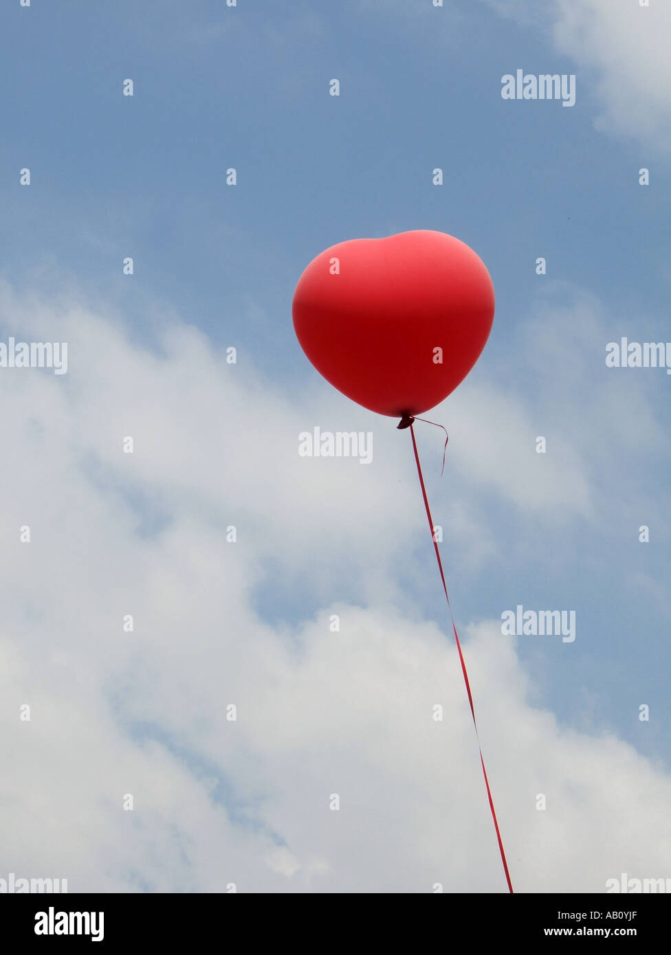 one heart shaped red balloon in blue sky Stock Photo - Alamy