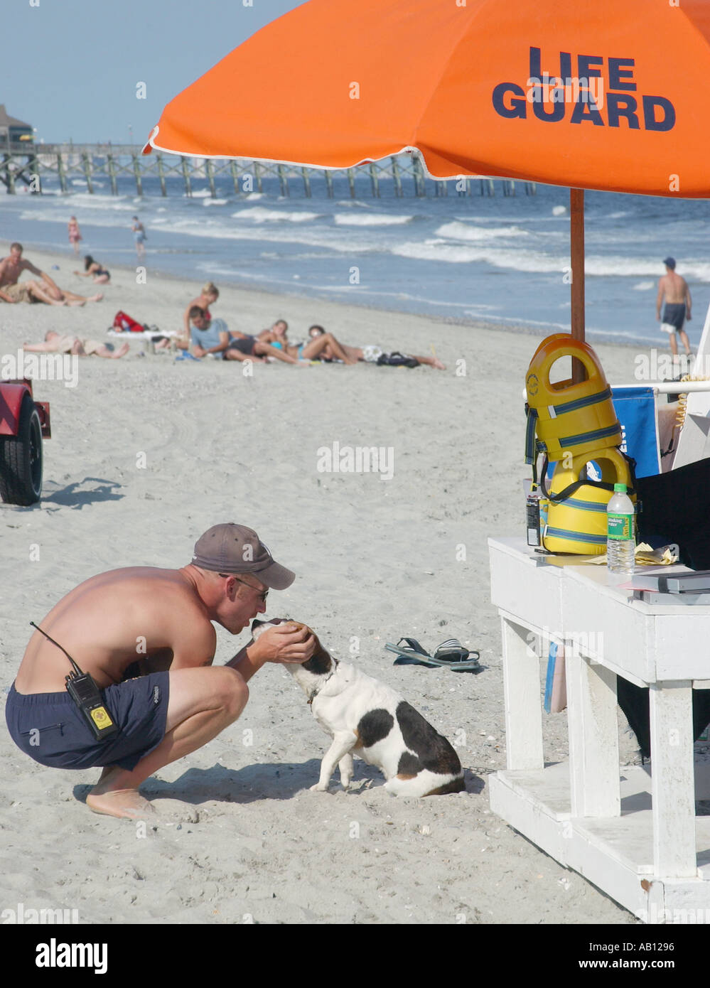 Lifeguard affectionately kisses a dog on the beach at Myrtle Beach ...