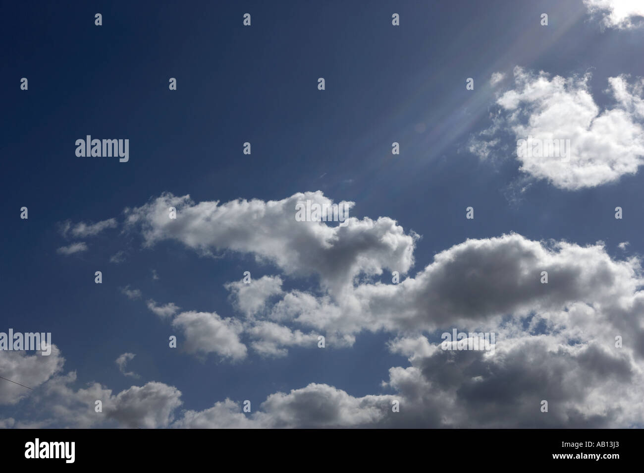 BRIGHT SUNLIGHT AND WHITE CLOUDS IN BLUE SKY Stock Photo - Alamy