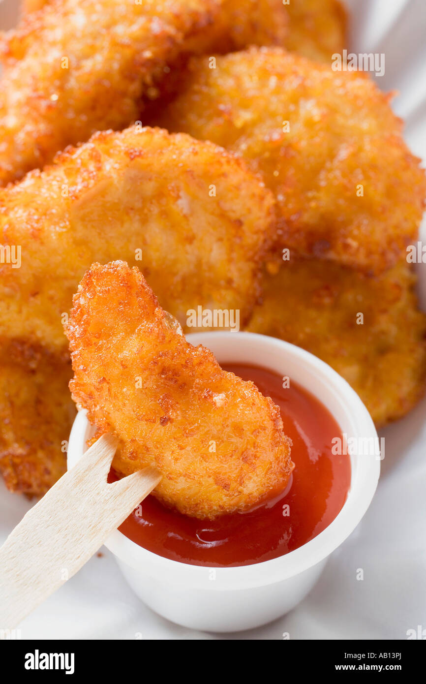 Dipping chicken nugget into ketchup with wooden fork FoodCollection ...
