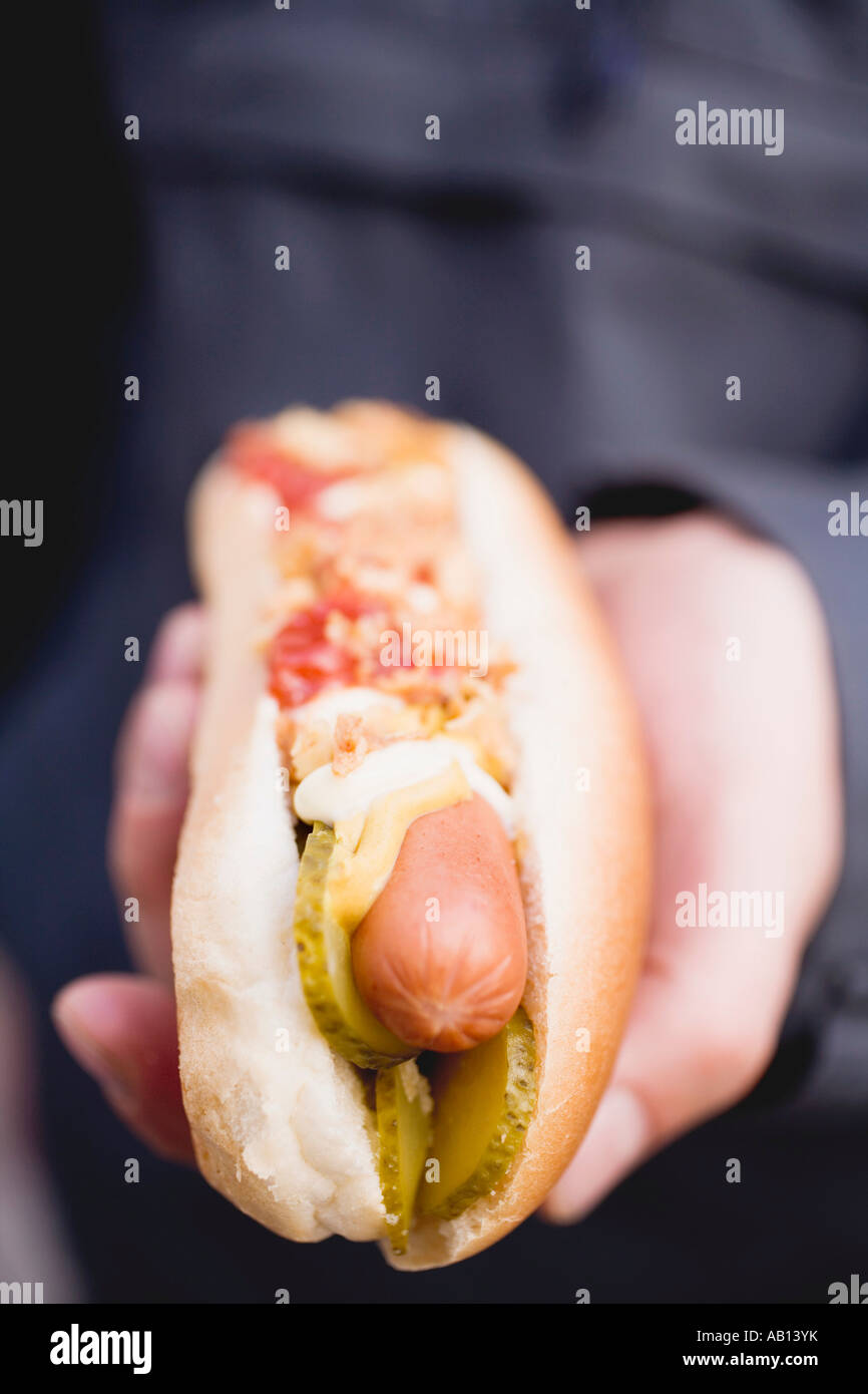 Hand holding a hot dog FoodCollection Stock Photo - Alamy