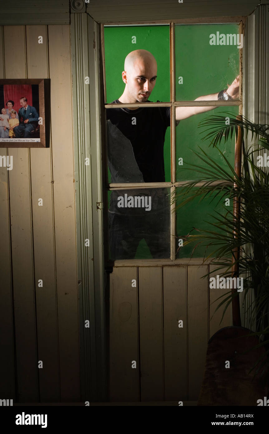 Sinister character in window, illuminated by harsh lighting Stock Photo ...