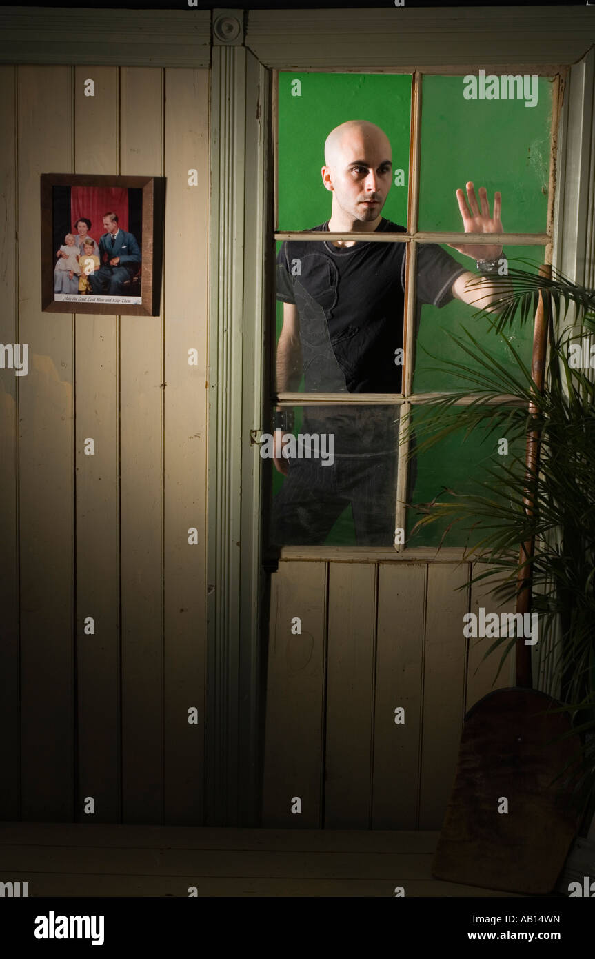 Sinister character in window, illuminated by harsh lighting Stock Photo ...