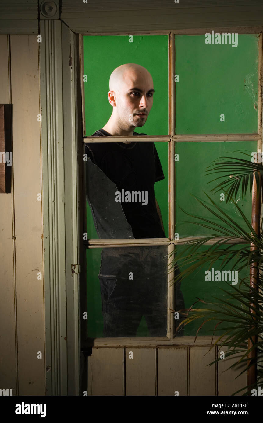 Sinister character in window, illuminated by harsh lighting Stock Photo ...