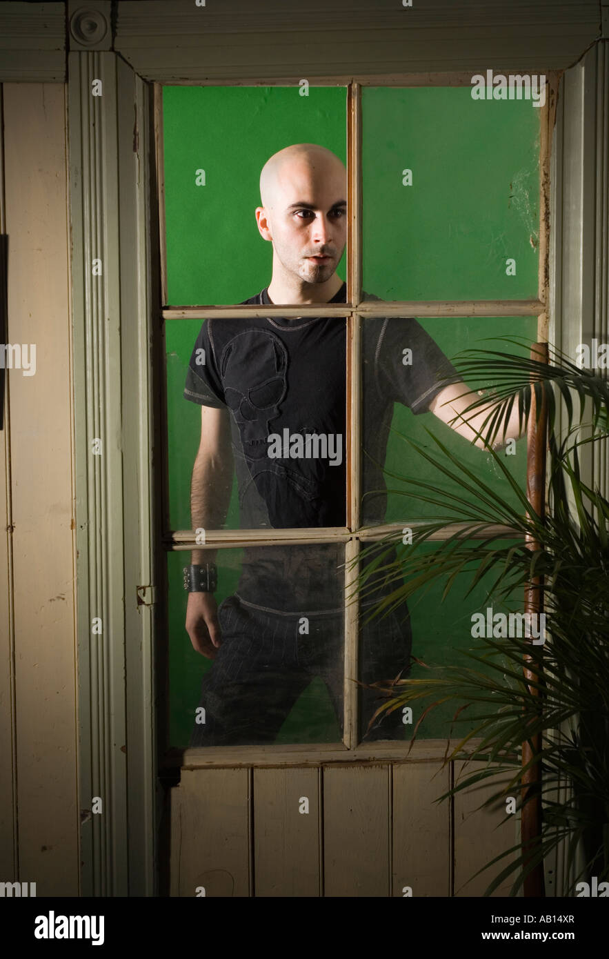 Sinister character in window, illuminated by harsh lighting Stock Photo ...
