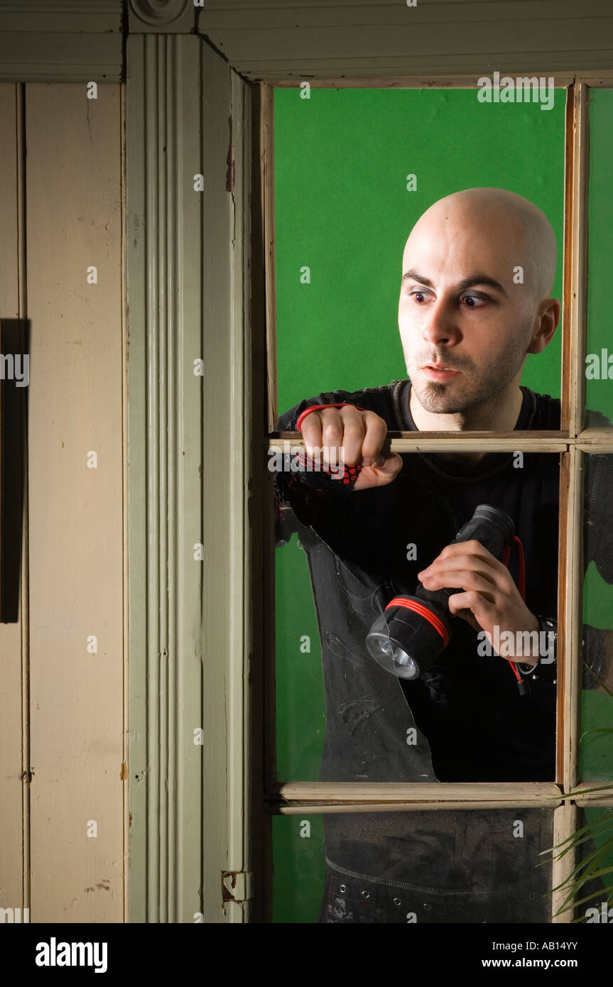Sinister character in window, illuminated by harsh lighting Stock Photo ...