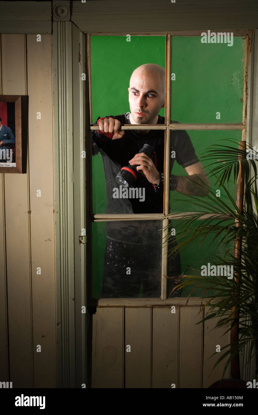 Sinister character in window, illuminated by harsh lighting Stock Photo ...