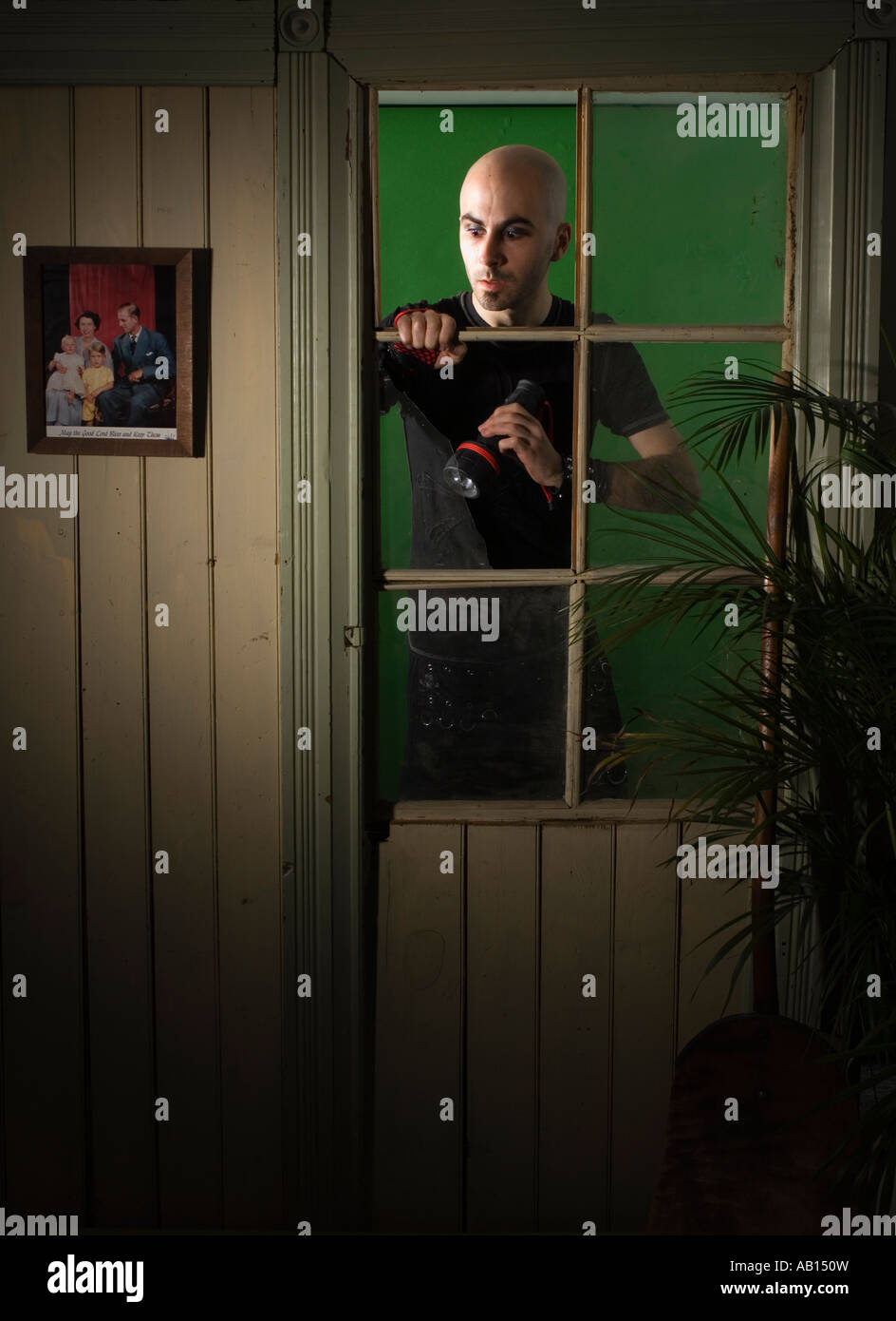 Sinister character in window, illuminated by harsh lighting Stock Photo ...