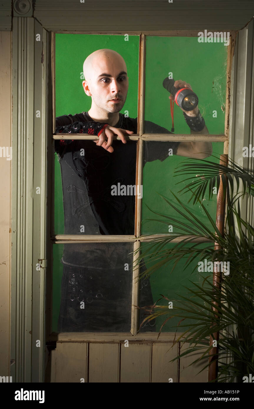Sinister character in window, illuminated by harsh lighting Stock Photo ...