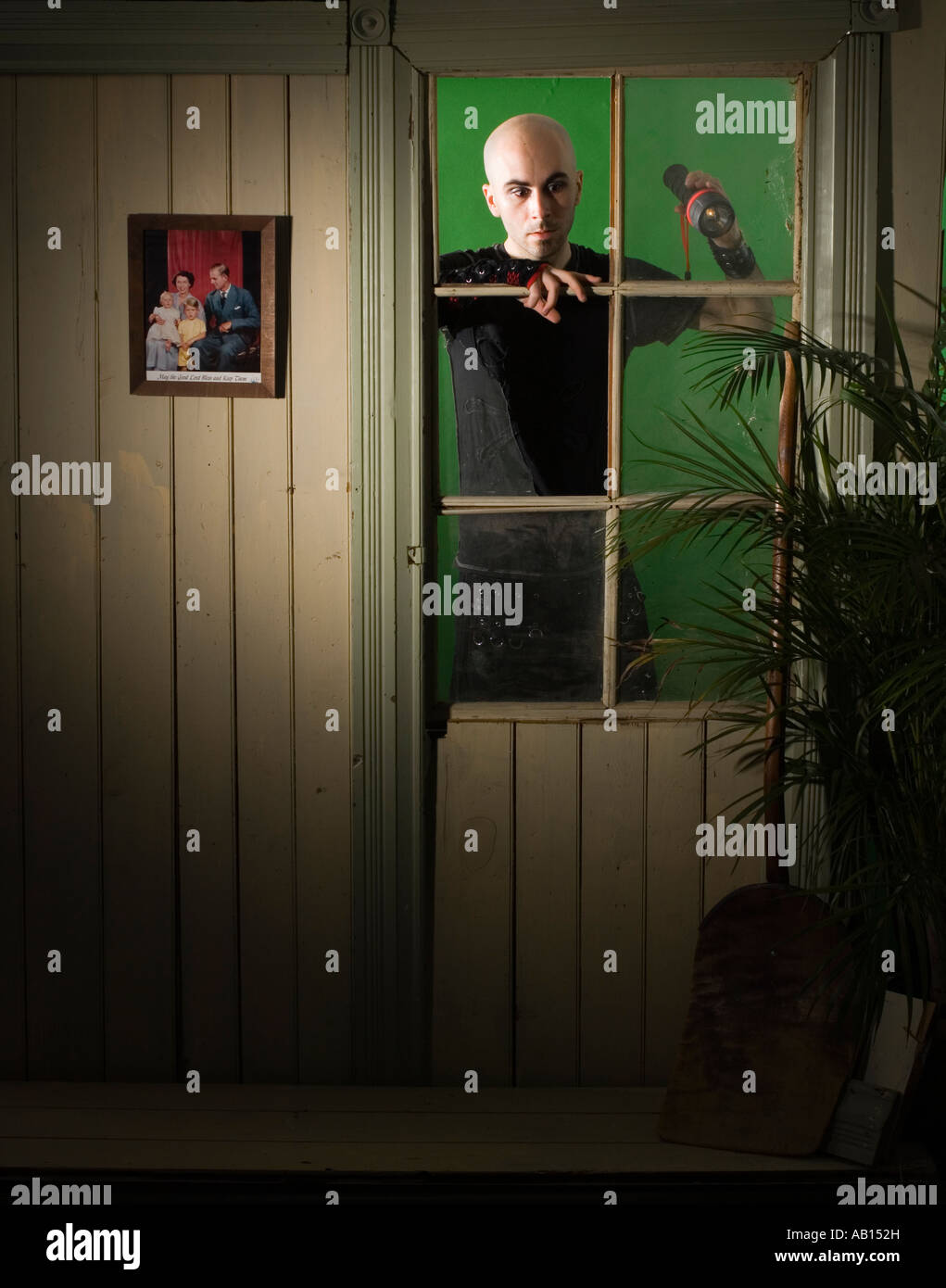 Sinister character in window, illuminated by harsh lighting Stock Photo ...