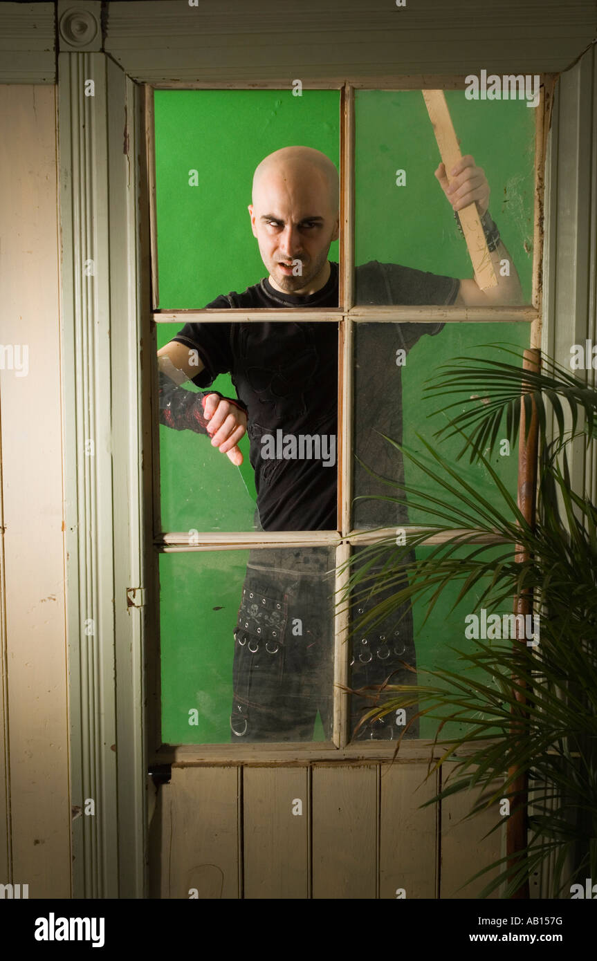 Sinister character in window, illuminated by harsh lighting Stock Photo ...