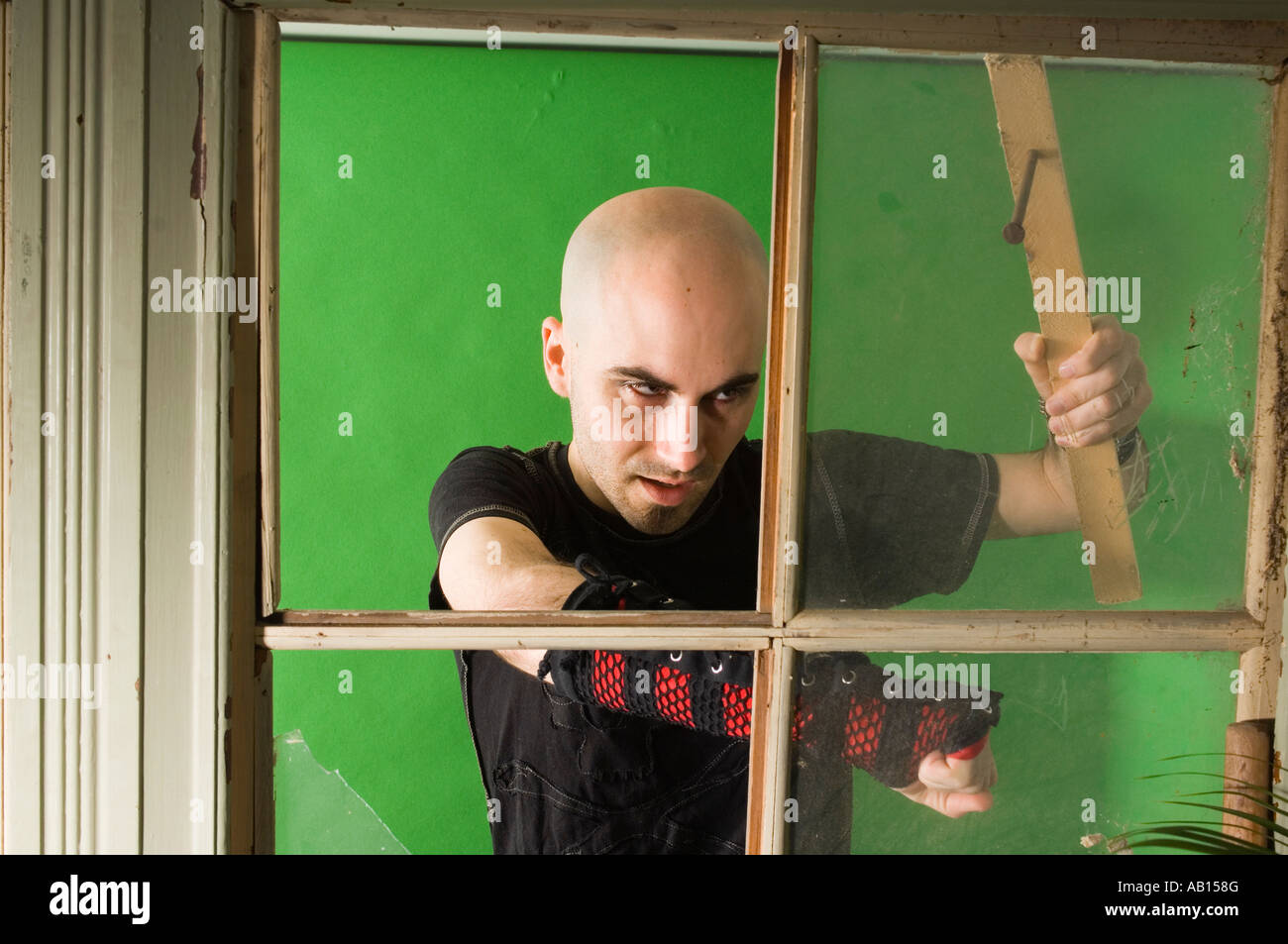 Sinister character in window, illuminated by harsh lighting Stock Photo ...