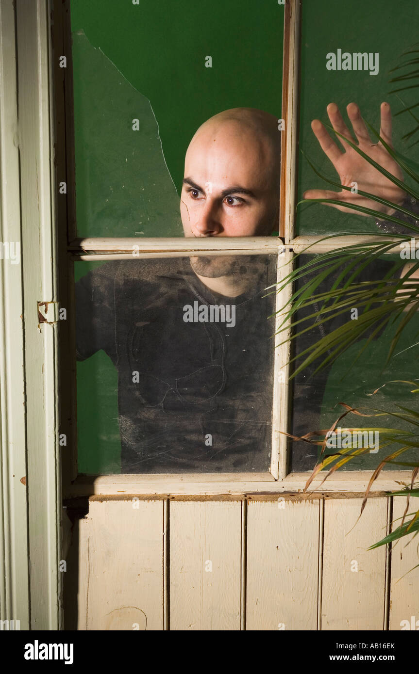 Man peering through glass hi-res stock photography and images - Alamy