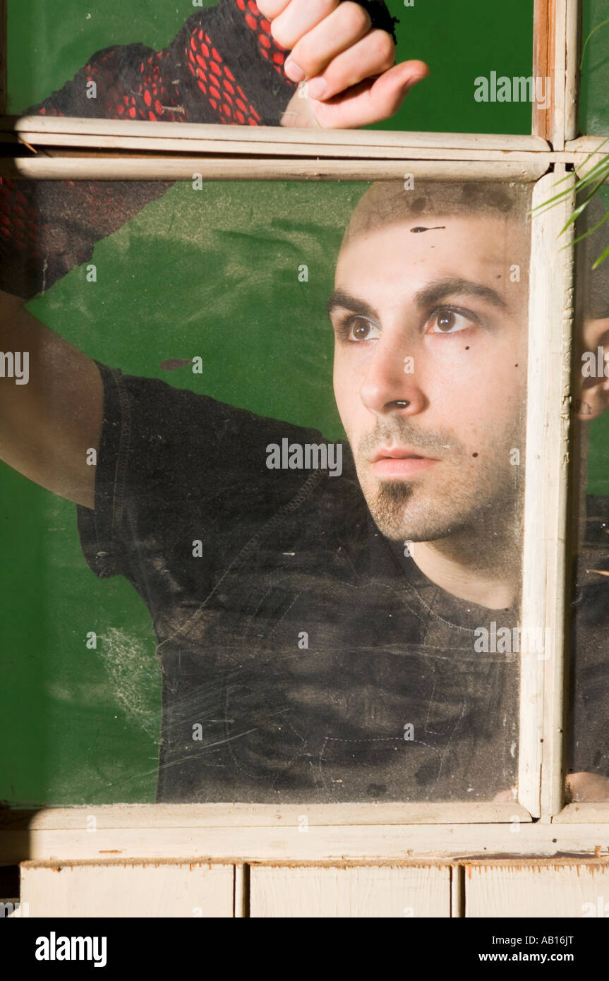 Sinister character peering through a broken window Stock Photo - Alamy