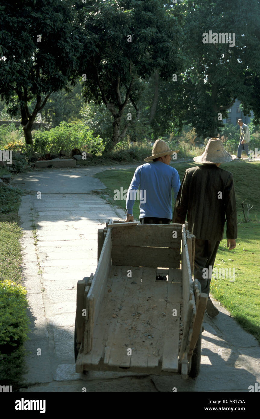 Chinese workers pulling cart on monastery grounds Stock Photo - Alamy