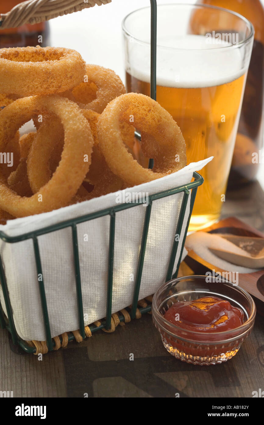 Deep fried onion rings in wire basket ketchup beer salt FoodCollection ...