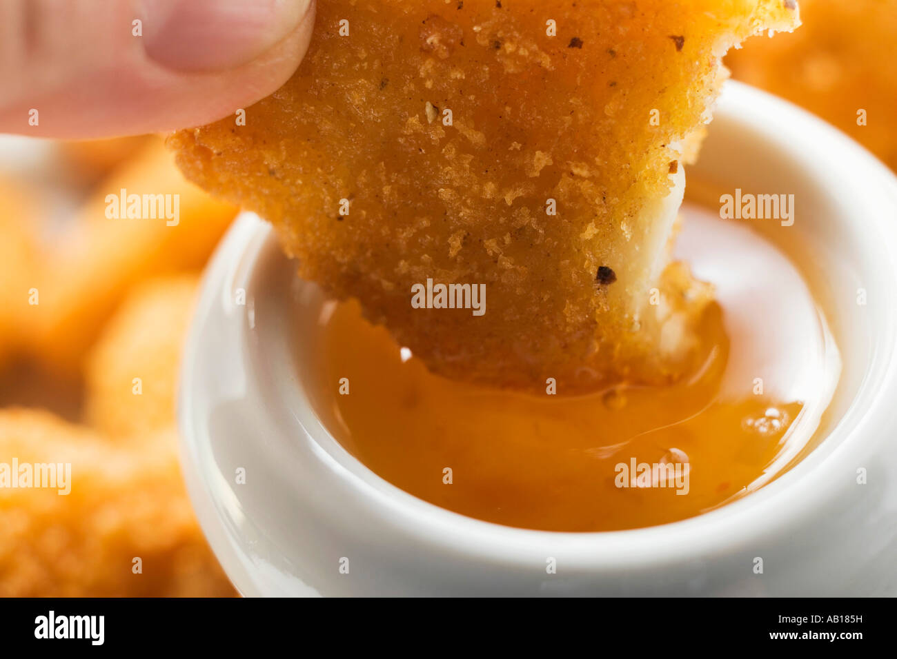 Dipping a chicken nugget in apricot sauce FoodCollection Stock Photo ...
