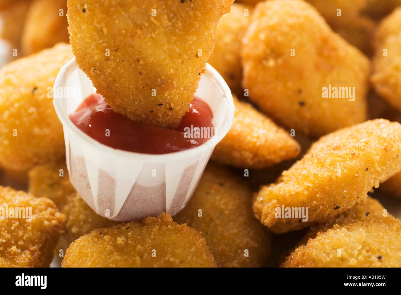 Dipping a chicken nugget in ketchup FoodCollection Stock Photo - Alamy