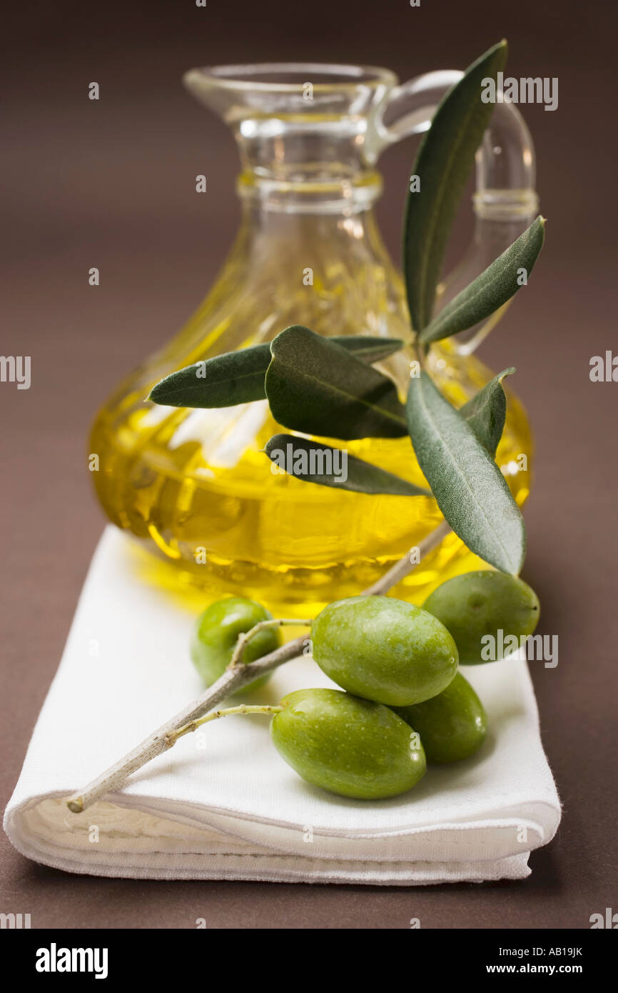 Olive sprig with green olives carafe of olive oil behind FoodCollection ...