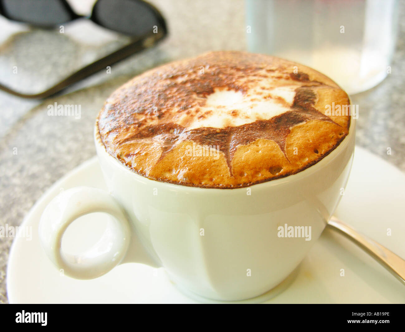 Cappuccino coffee with artistic chocolate pattern on froth sunglasses ...
