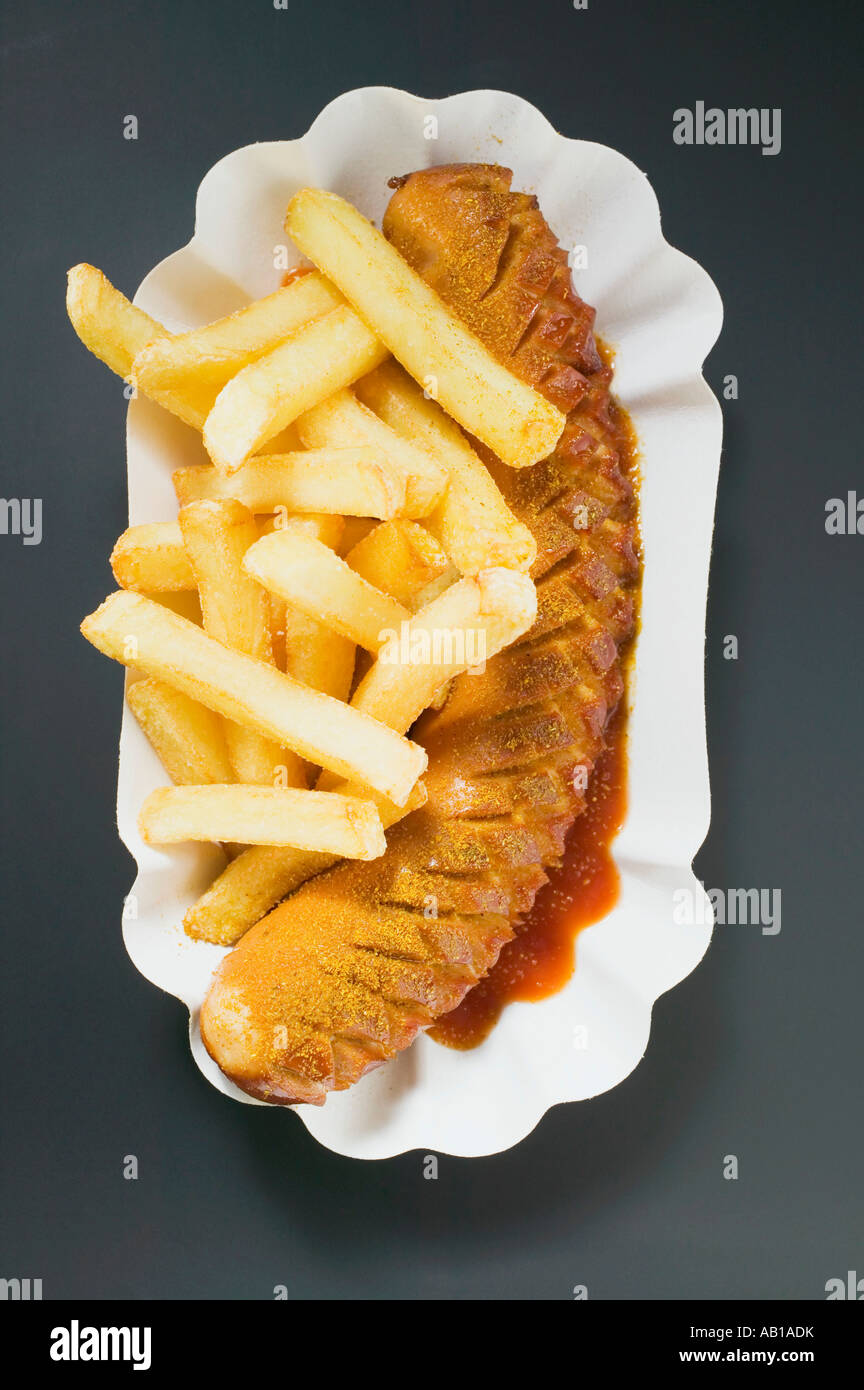 Currywurst sausage with ketchup curry powder chips in paper dish ...