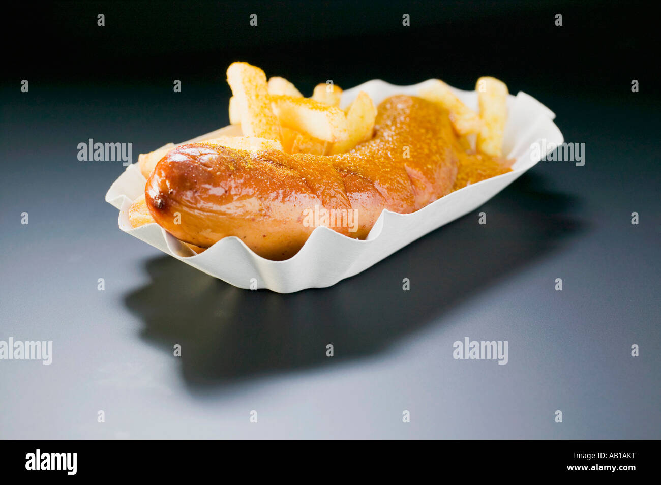 Currywurst sausage with ketchup curry powder chips on paper dish ...