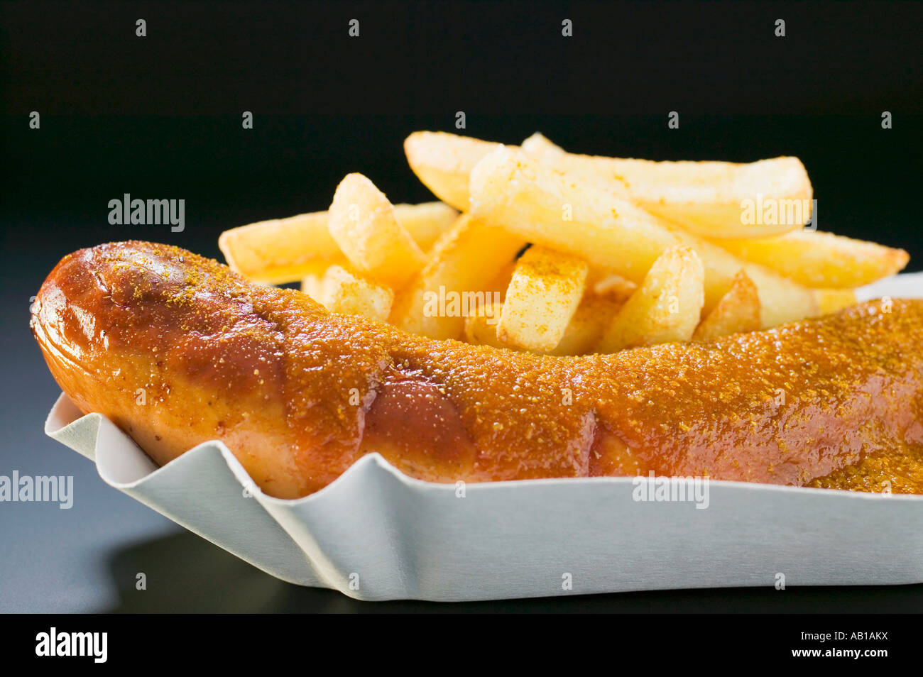 Currywurst sausage with ketchup curry powder chips in paper dish ...