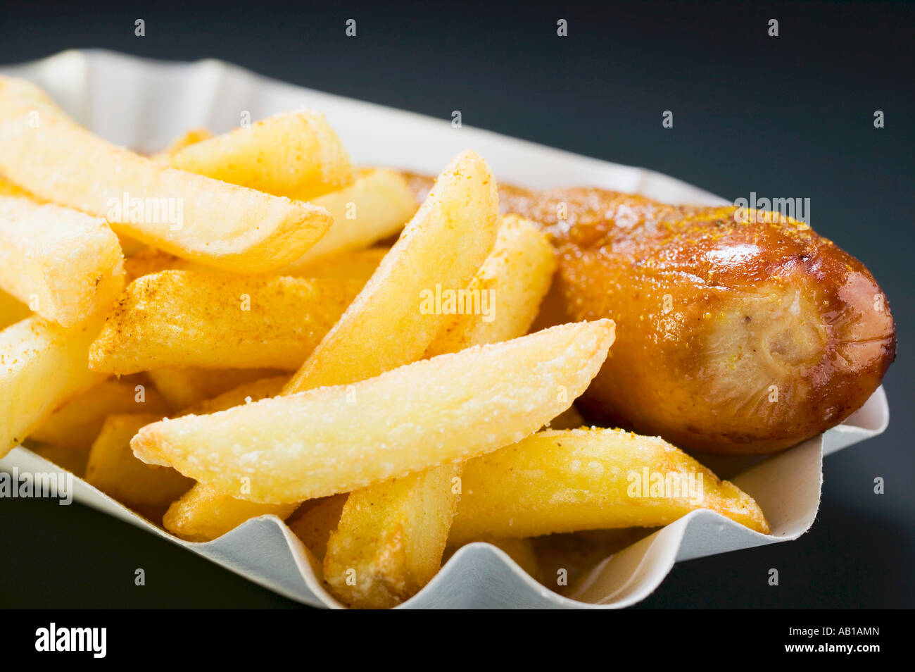 Currywurst sausage with ketchup curry powder chips in paper dish ...