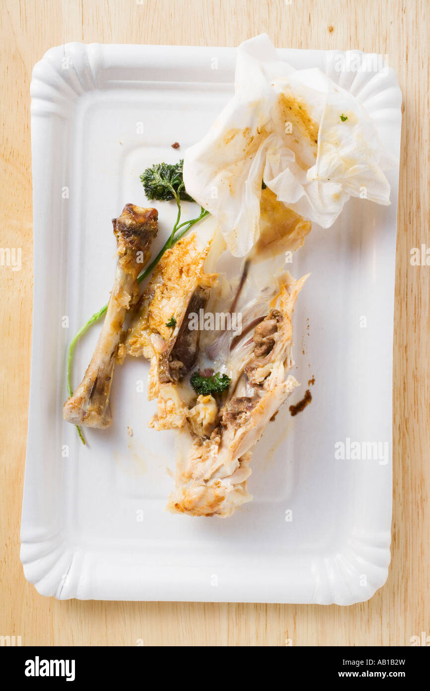 Remains of roast chicken and paper napkin on paper plate FoodCollection ...