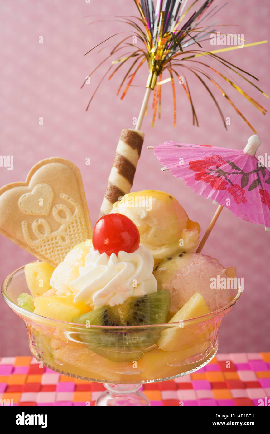 Ice cream sundae with fresh fruit and cocktail umbrella FoodCollection ...