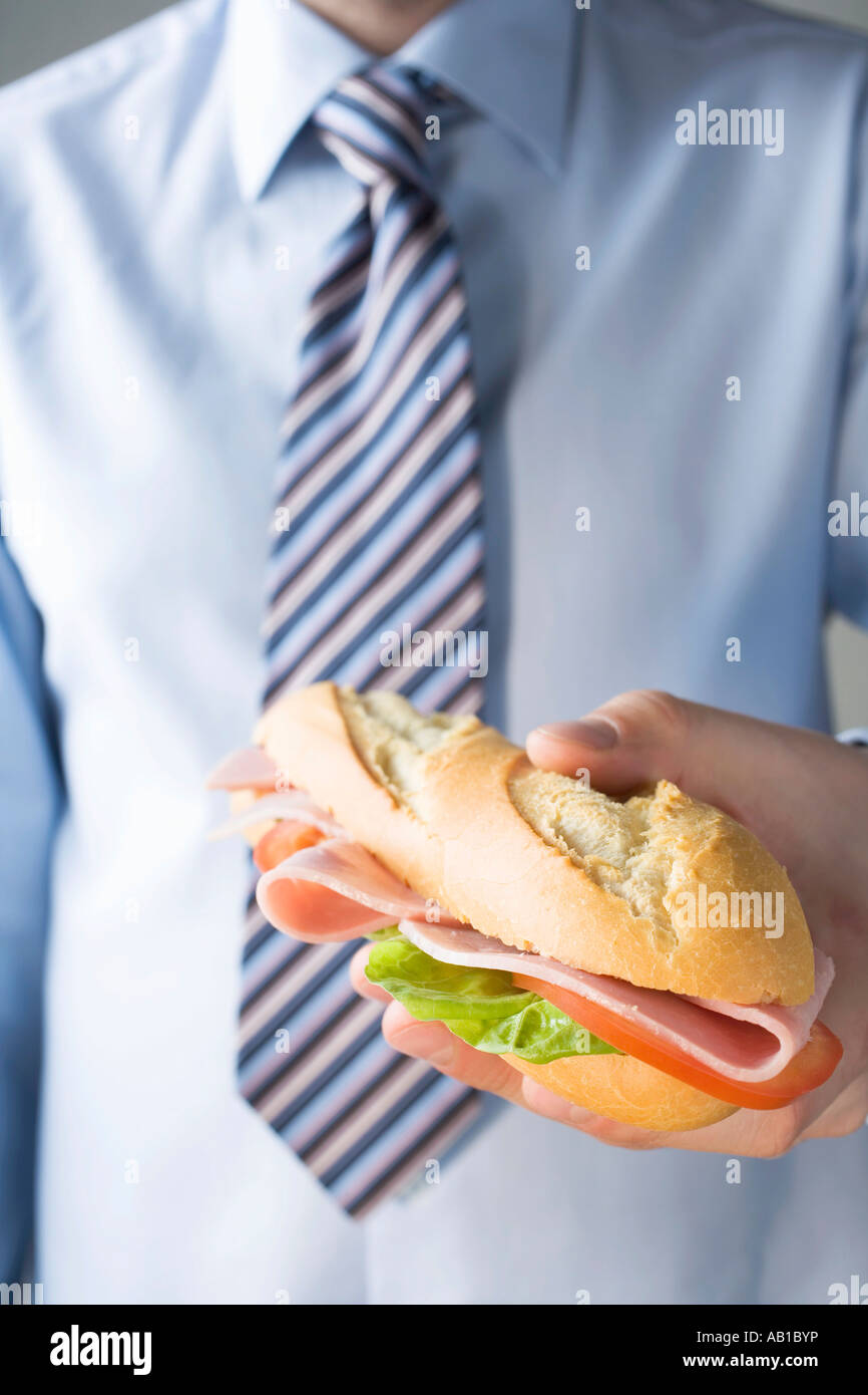 Man in tie holding ham sub sandwich FoodCollection Stock Photo - Alamy