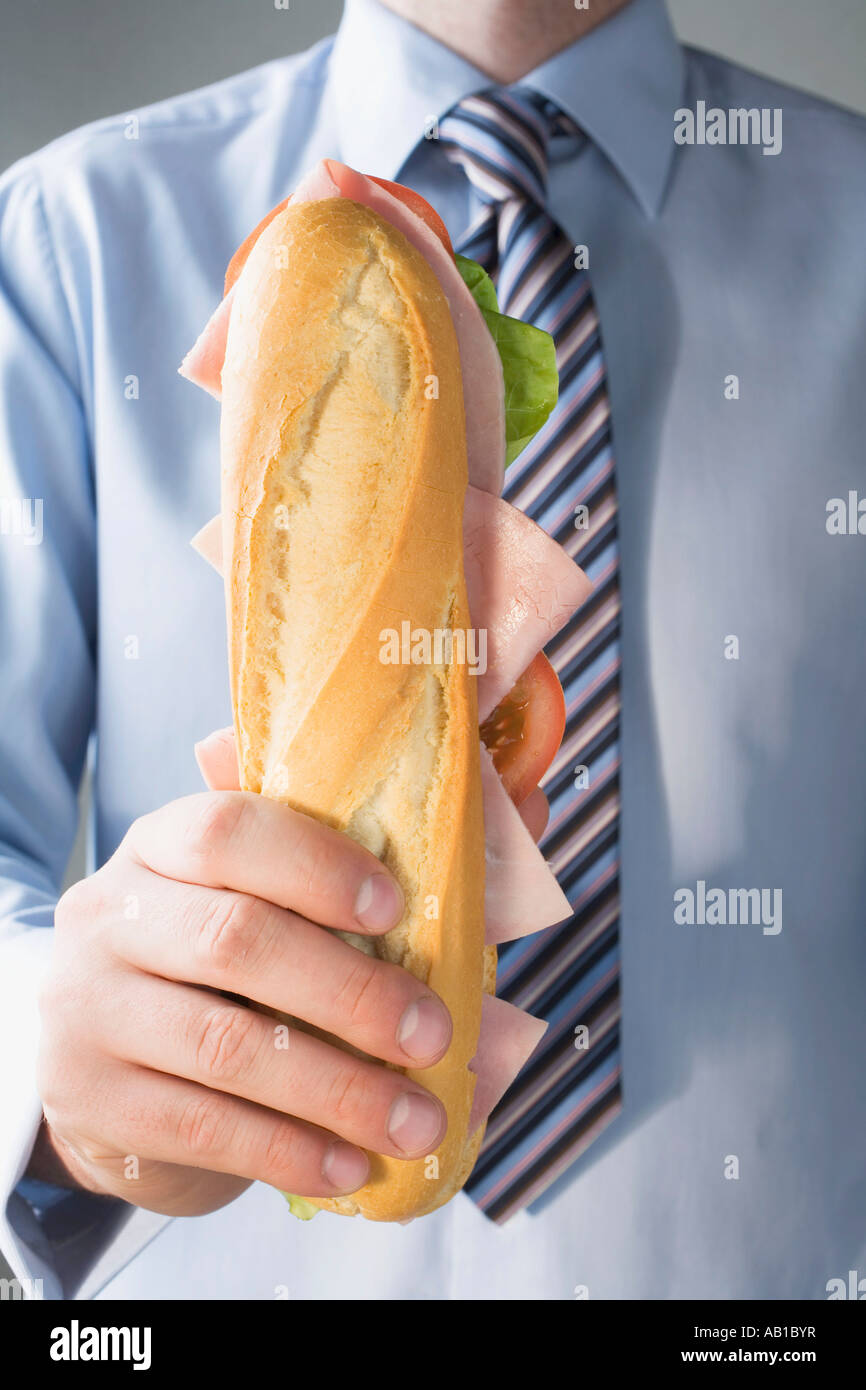 Man in tie holding ham sub sandwich FoodCollection Stock Photo - Alamy