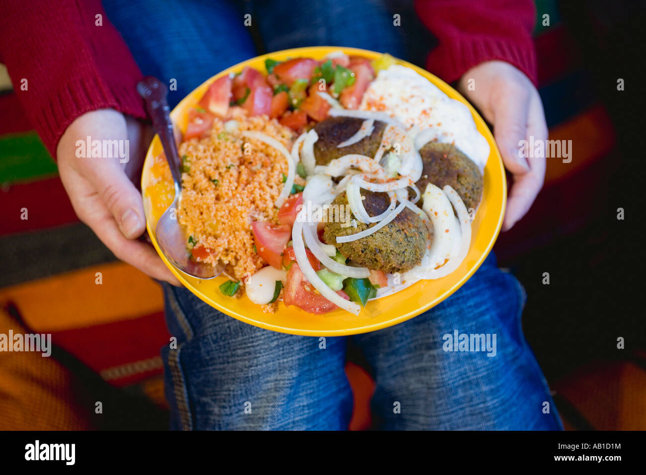 Person holding falafel with accompaniments N Africa FoodCollection ...