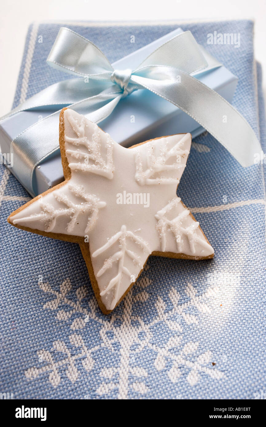 Gingerbread star with white icing in front of gift FoodCollection Stock ...