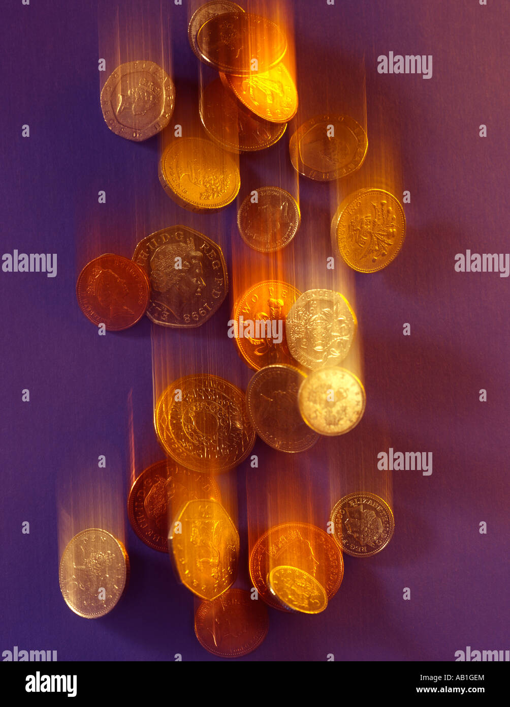 Falling coins against purple background with movement Stock Photo - Alamy