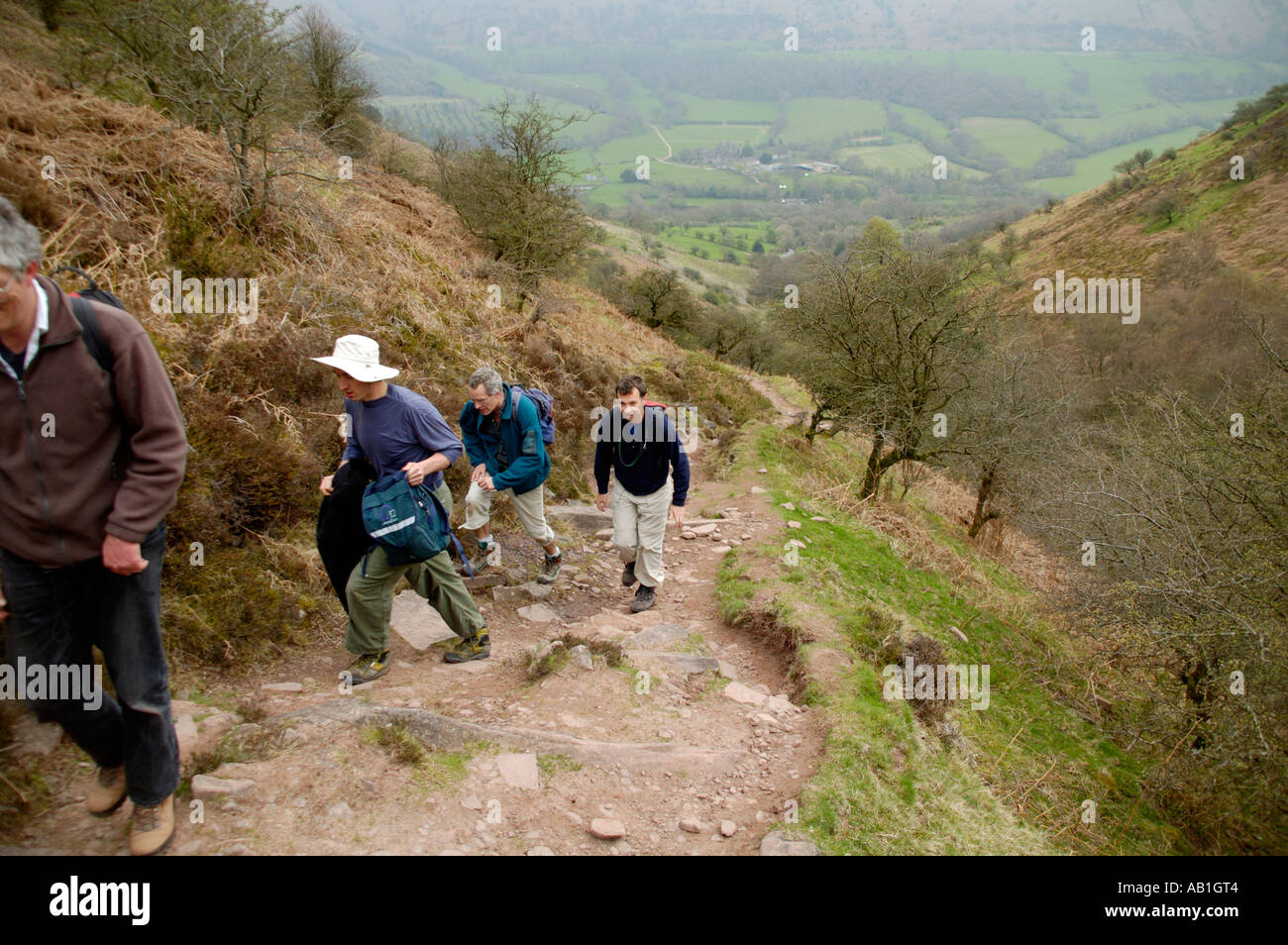 Guided group walking up Cwm Bwchel footpath opposite Llanthony Priory ...