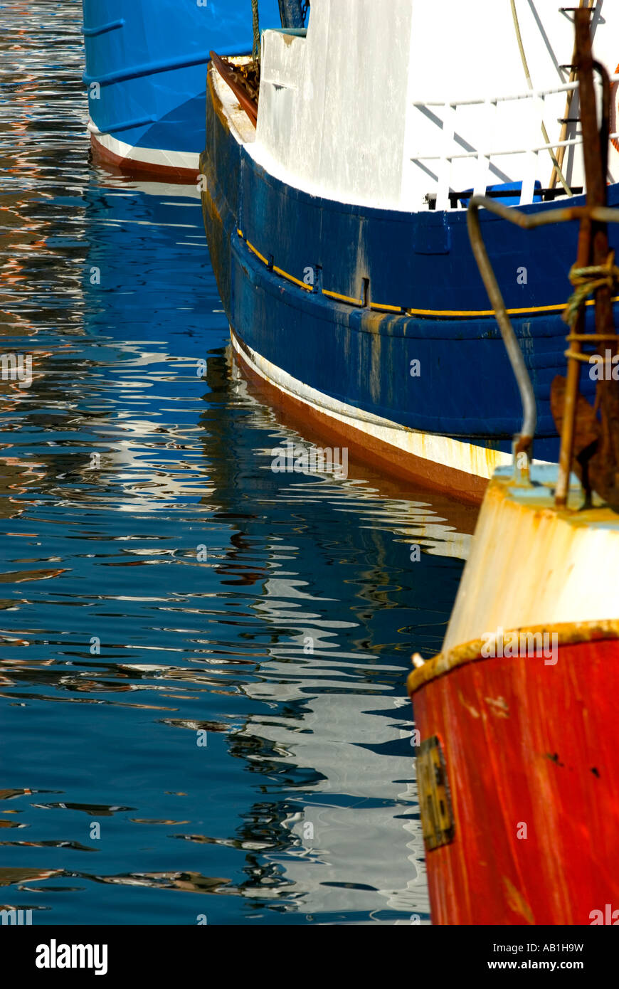 three fishing boats red blue white Stock Photo - Alamy