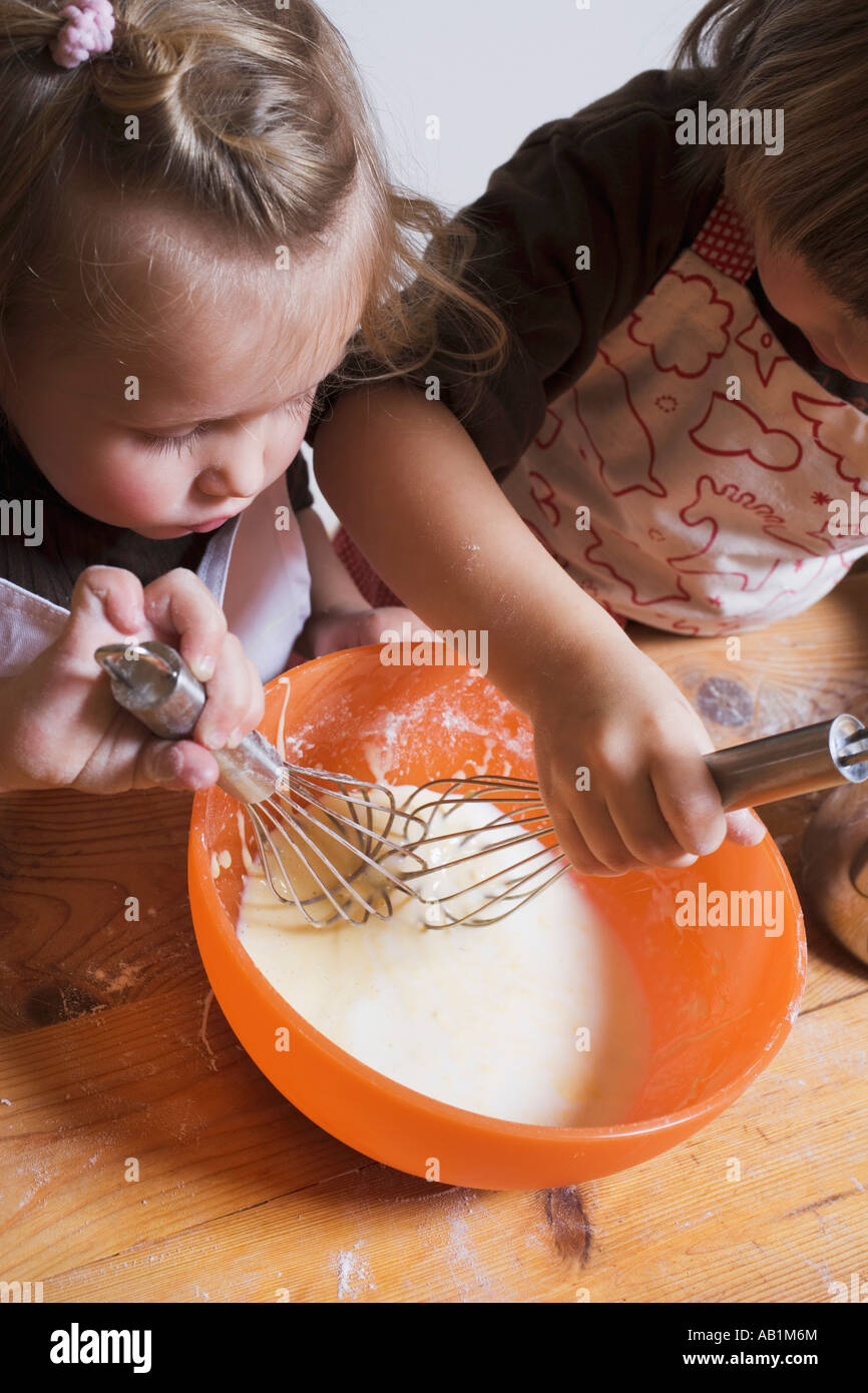Two children stirring cake mixture with whisks FoodCollection Stock ...